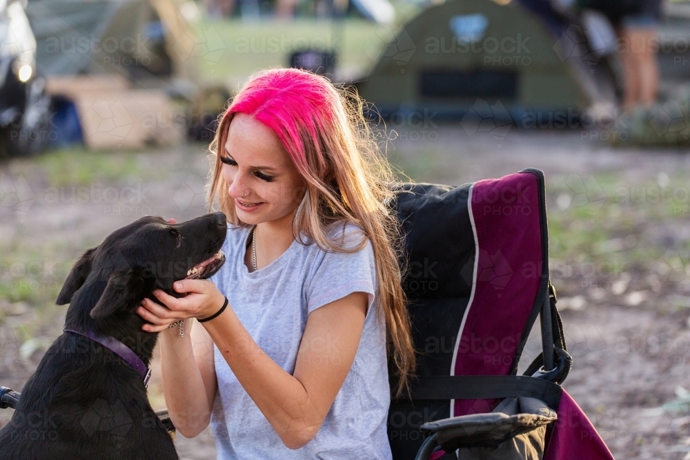 Image of Happy young Australian person interacting with her dog while ...
