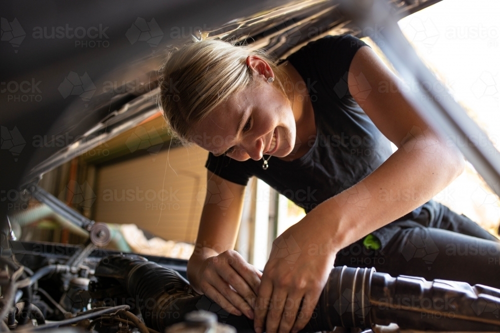 Image of Happy young australian tradesperson mechanic fixing car ...