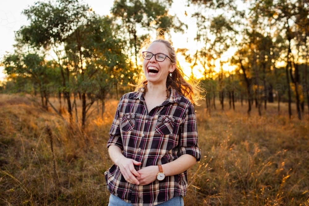 Image of Happy young australian woman laughing in country paddock ...