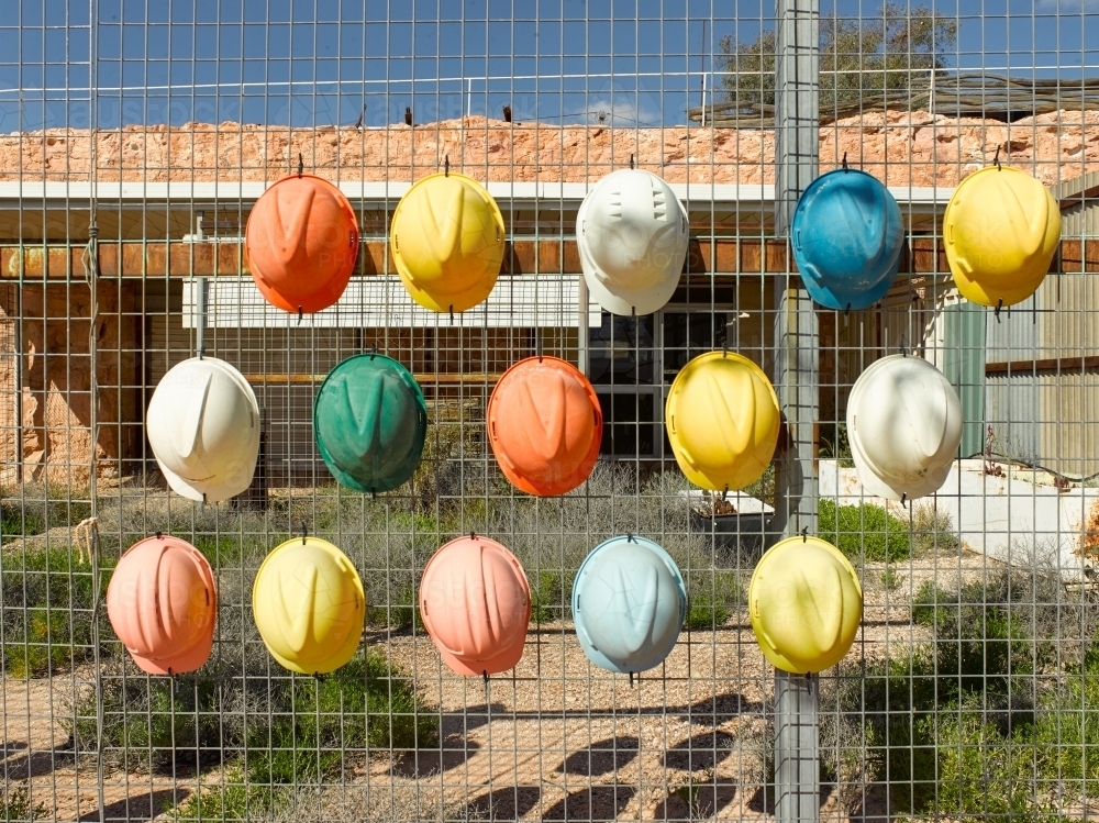 Image of Hard hats on fence at a tourist mine - Austockphoto