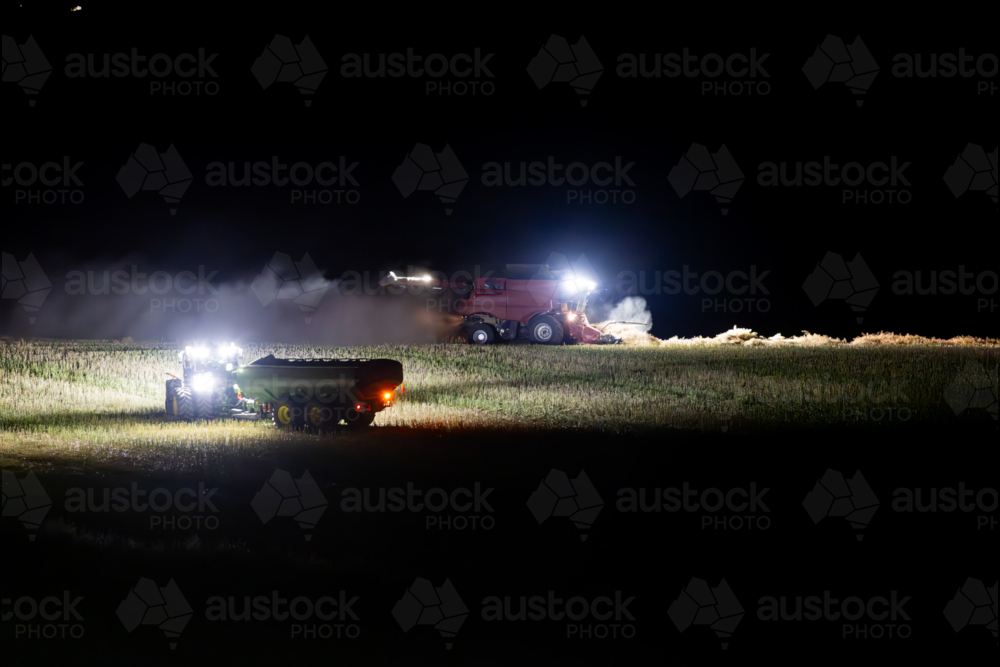 Image of Harvester harvesting canola crop at night with chaser bin on ...