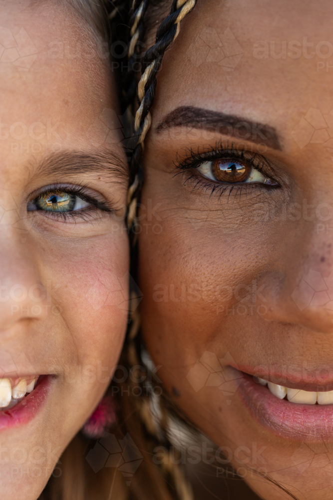 Image of Hazel and brown eyes of First Nations Australian girl and mother with faces close ...