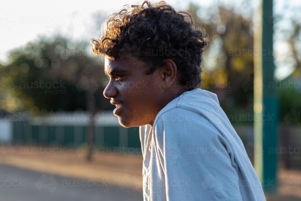 Image of head and shoulders of aboriginal boy in profile - Austockphoto