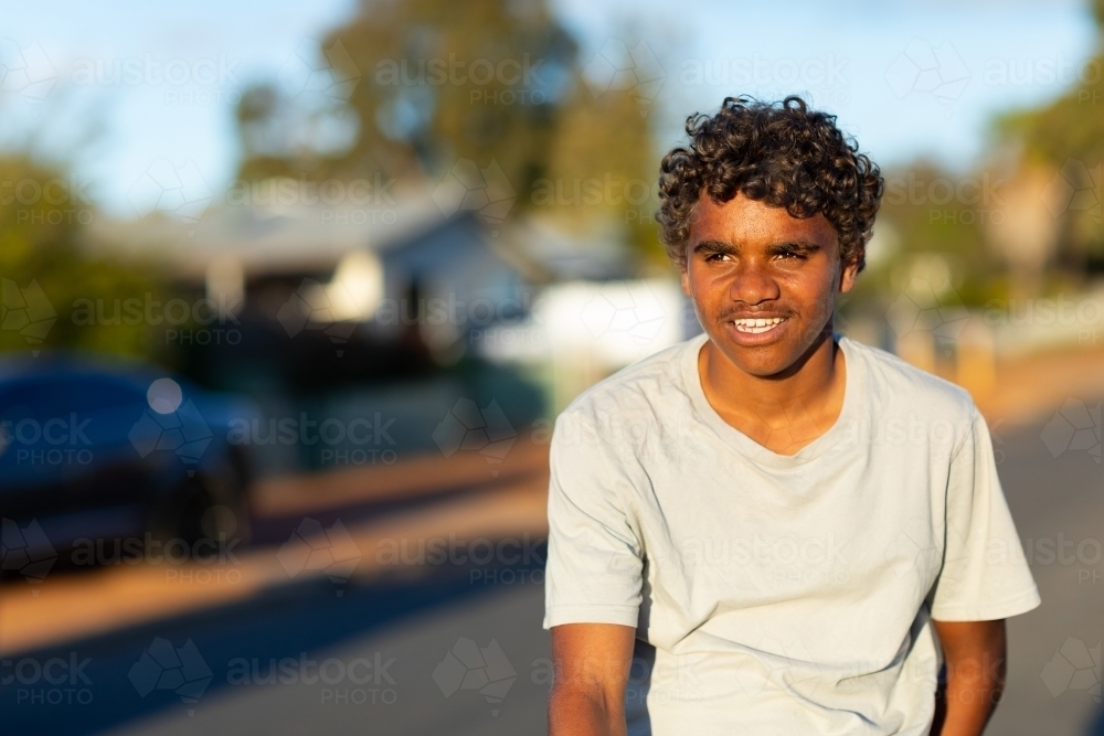 Image of head and shoulders of aboriginal boy outdoors in town ...