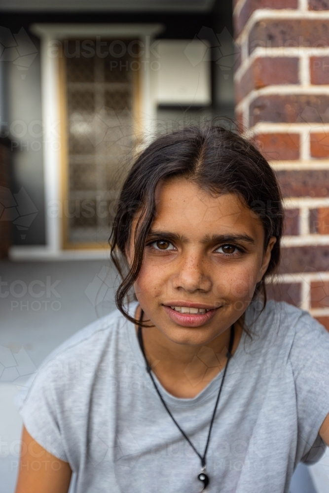 Image of head and shoulders of aboriginal girl sitting outside in front ...