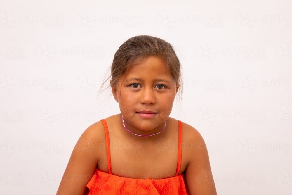 Image of Head and shoulders of Maori child on plain background looking ...