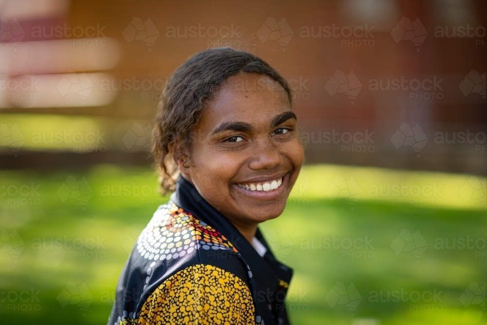 Image of head and shoulders of smiling teenage girl looking over ...