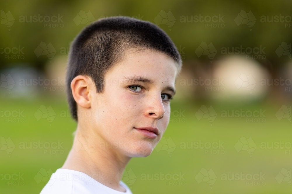 Image of head and shoulders of tween child looking out corner of his ...