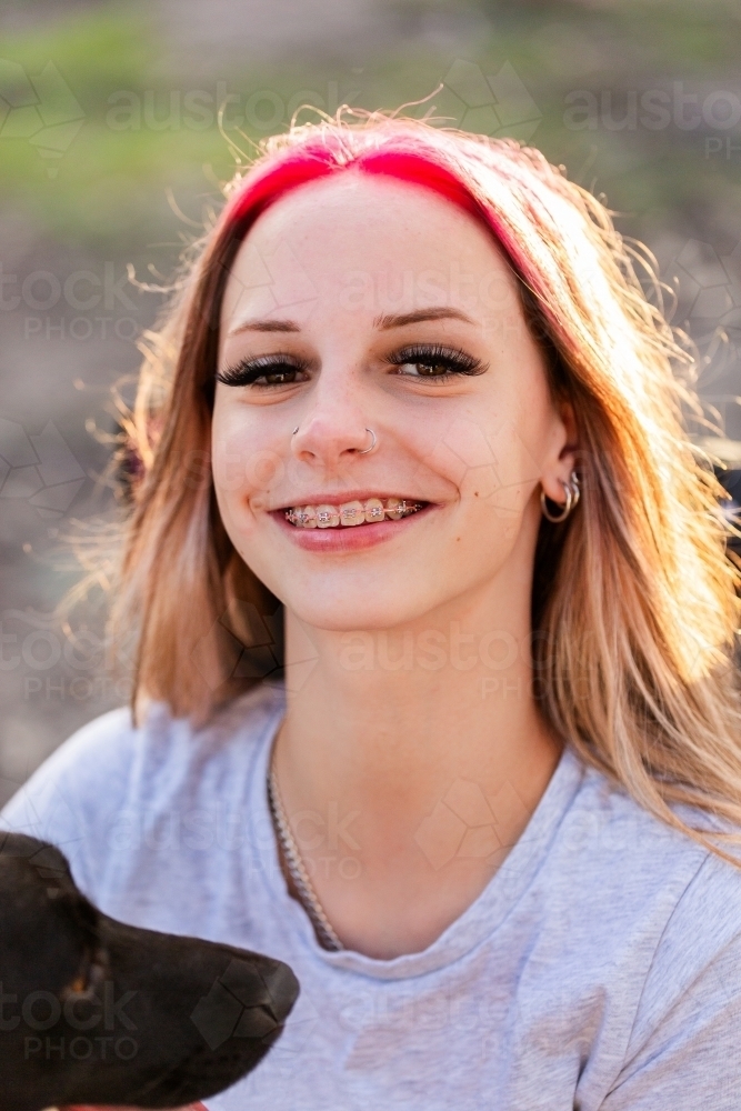 Image of Headshot portrait of happy teenage girl with pink hair outside ...