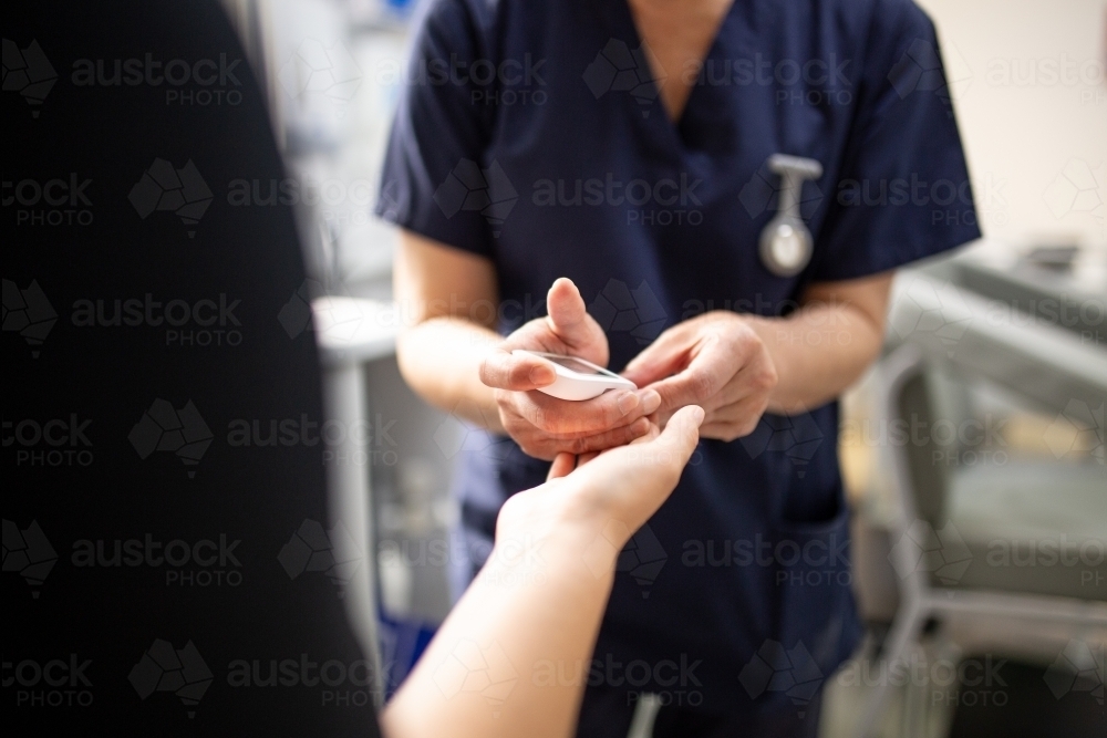 Image of Health worker getting a blood sample from a woman using a ...