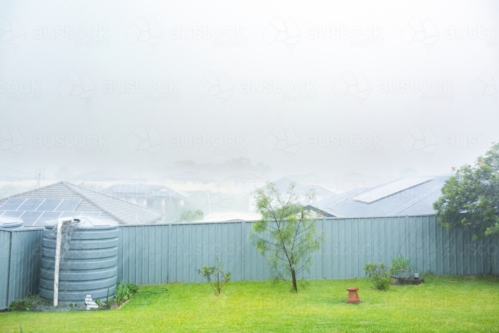 Image of Heavy flash flood rainfall in suburban area with rain and tank ...