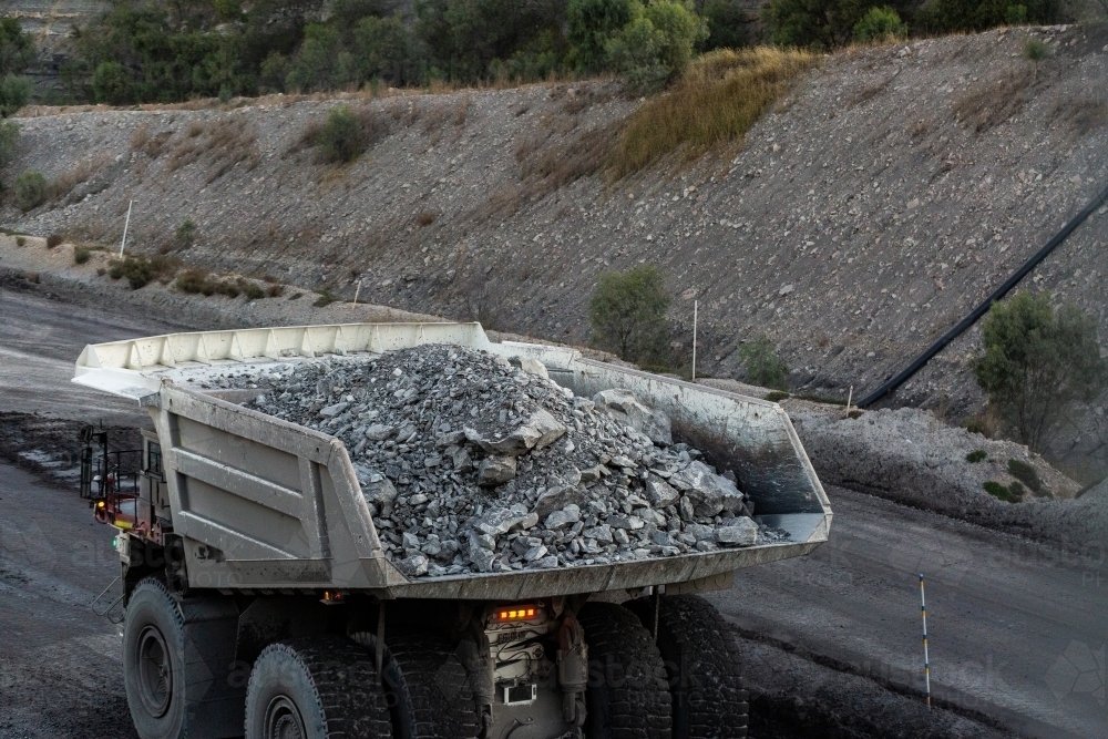 Image of Heavy mine machinery driving away in open cut coal mine moving ...
