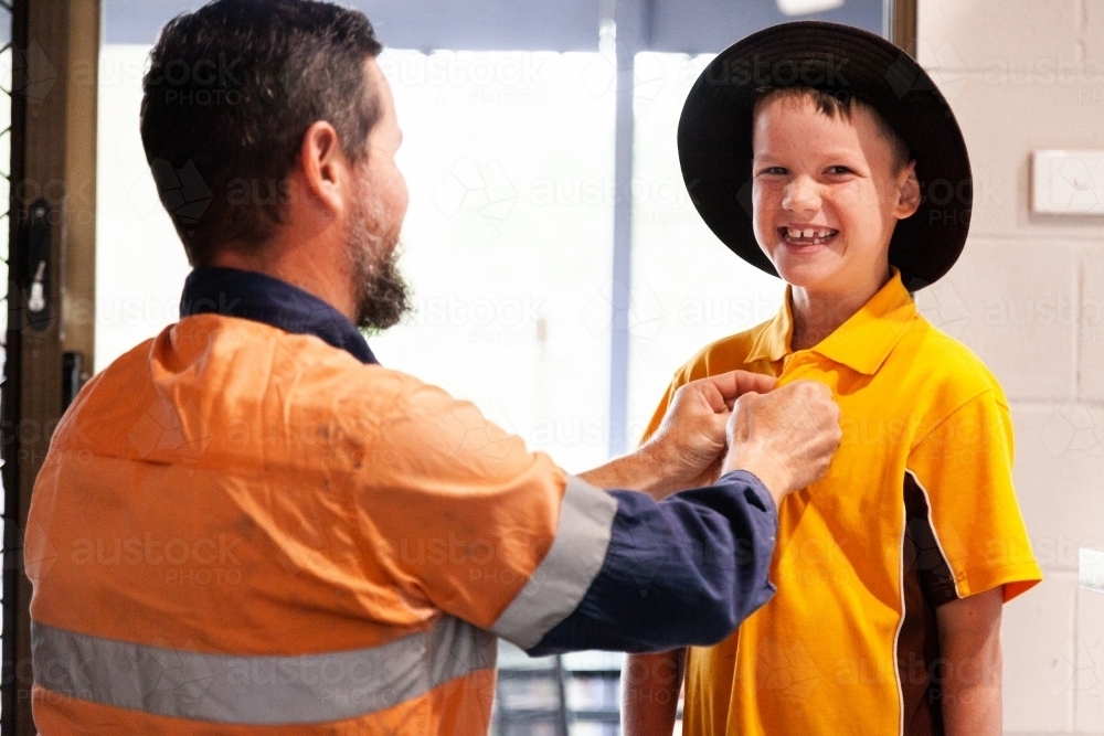 Image of Helping to do up button on shirt before school - Austockphoto