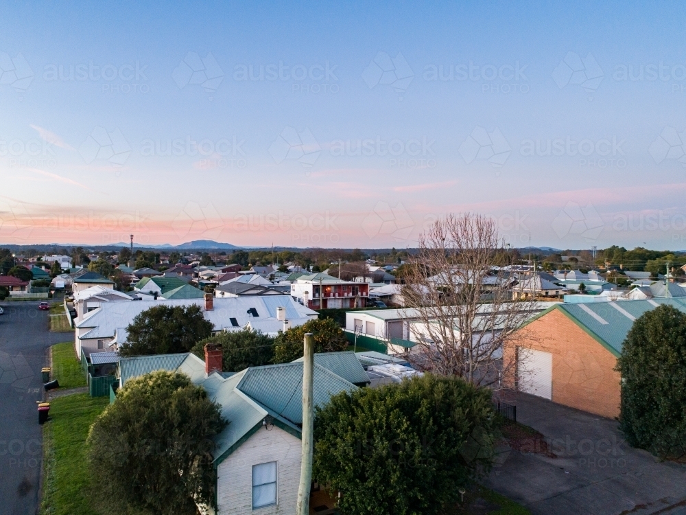 Image of high angle view over houses in country town at dusk - Austockphoto