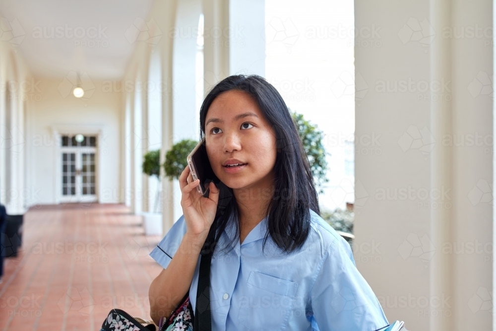Image of High School student making call on-campus - Austockphoto