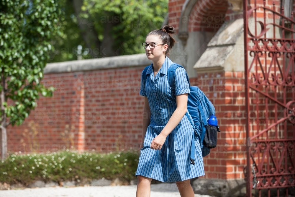 Image of high school student walking through school gates - Austockphoto