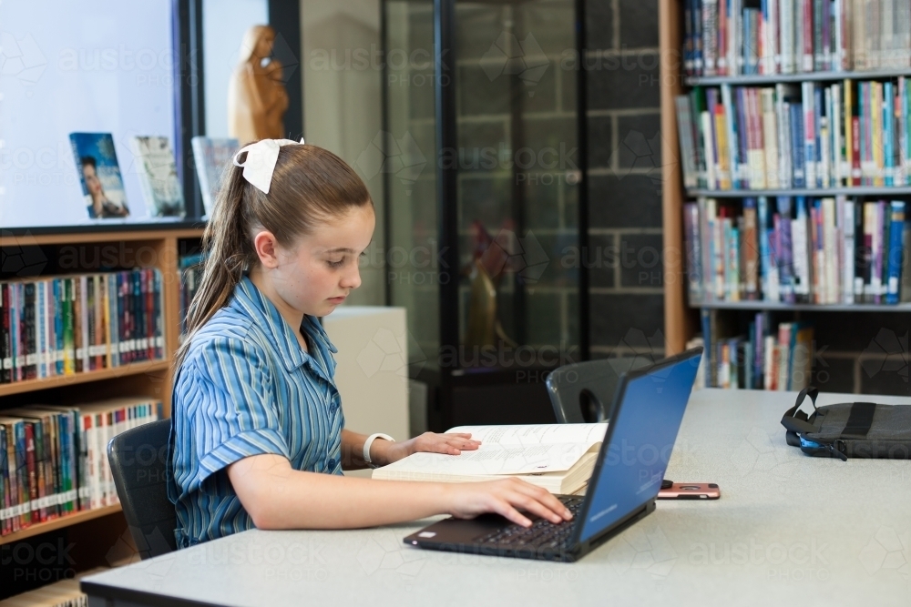 Image of High school student working in the library - Austockphoto