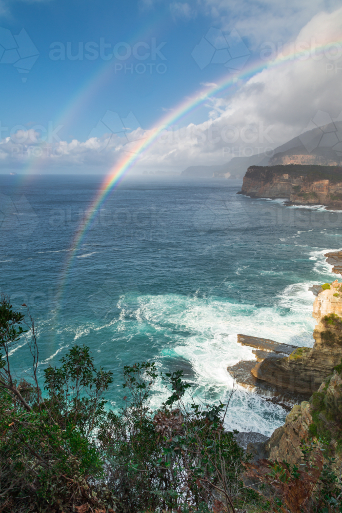 Image of High view of a double rainbow over rugged coastal cliffs ...