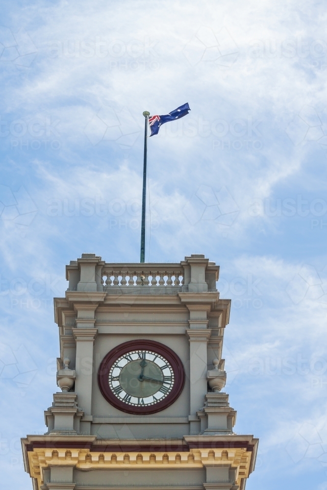Image of Historic clock tower flying an Australian flag against a blue ...