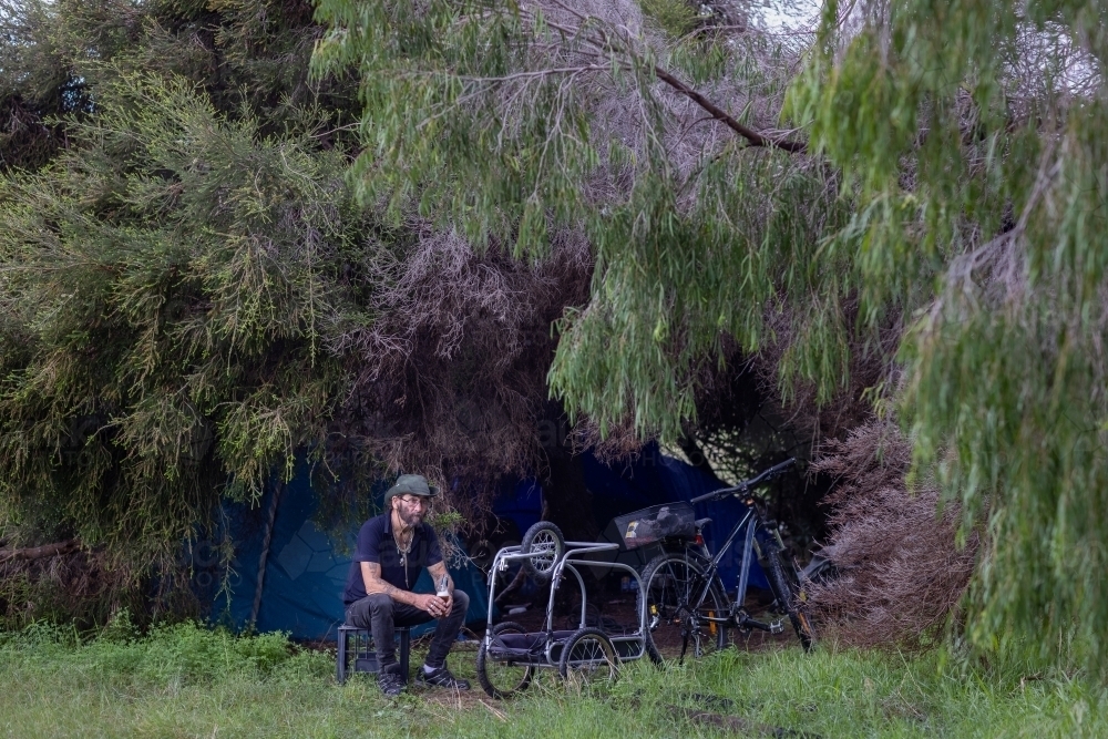 Image of homeless man with his bike and trailer at his camp hidden ...