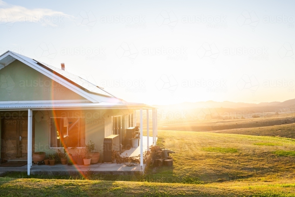 Image of Homestead on hilltop with last rays of sunlight shining over ...