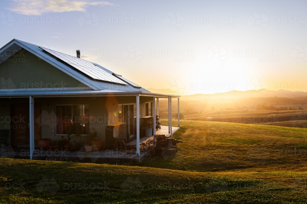 Image of Homestead on hilltop with last rays of sunlight shining over ...