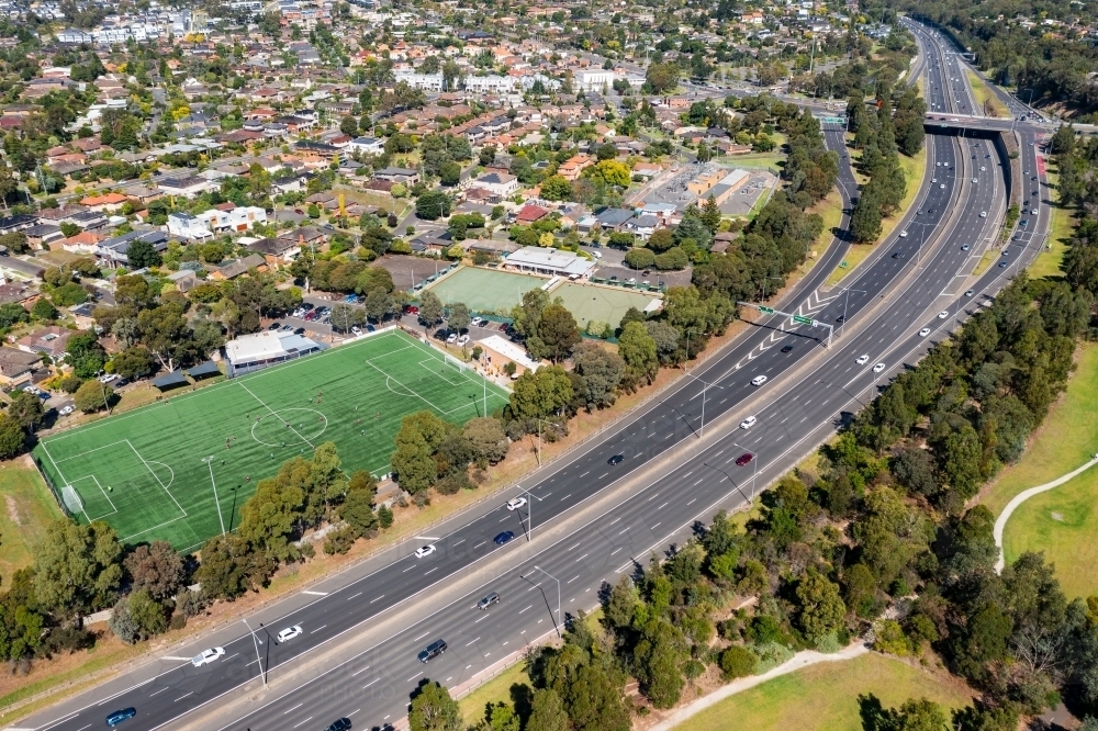 Image of Horizontal aerial view of a long, curved freeway along side a ...