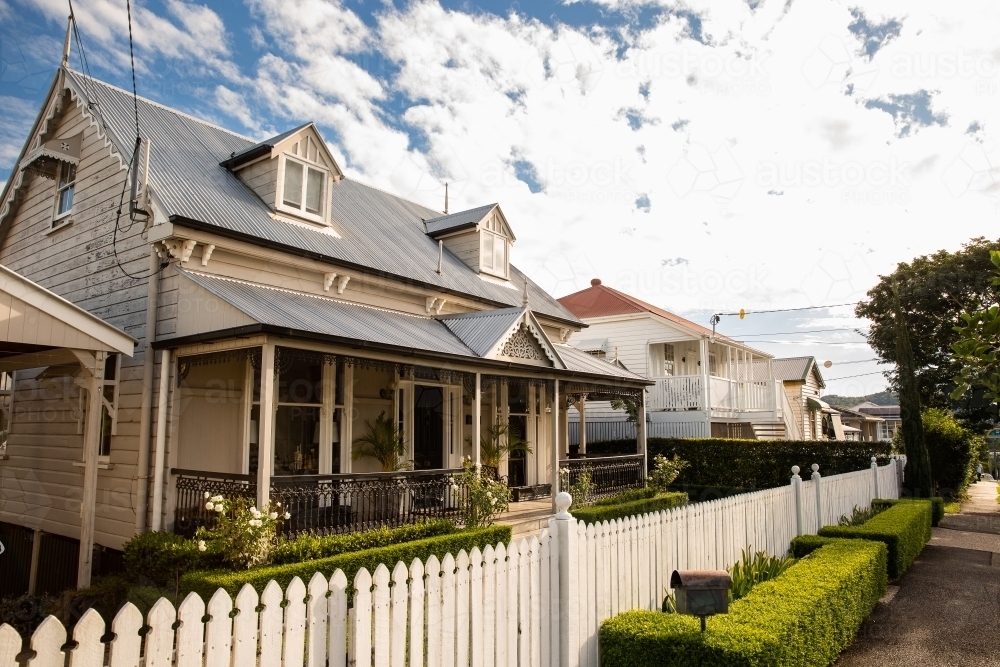 Image of house with dormer windows on a street with other nice houses ...