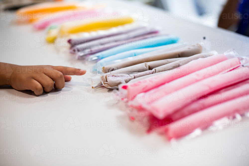 Image of ice blocks lined up on a bench in colour order - Austockphoto