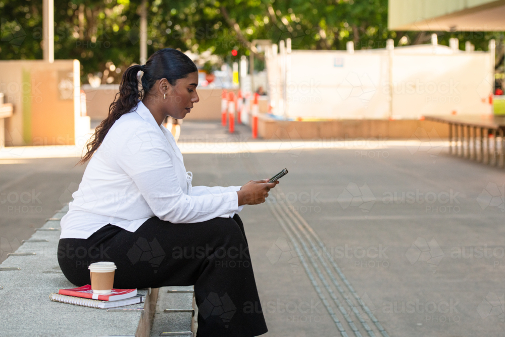 Image of indian australian woman using phone in an outdoor setting ...
