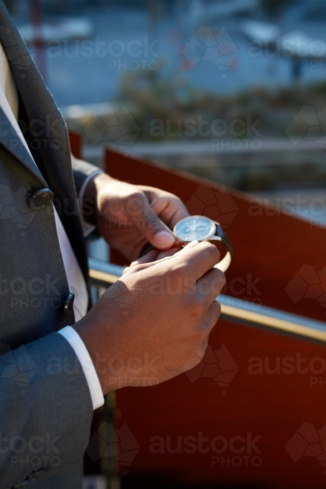 Image of Indian businessman checking time on watch outdoors in city ...