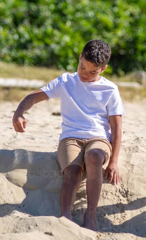 Image of Indigenous boy playing on a sand ledge - Austockphoto