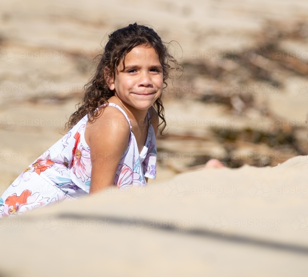 Image of Indigenous girl playing in the sand - Austockphoto