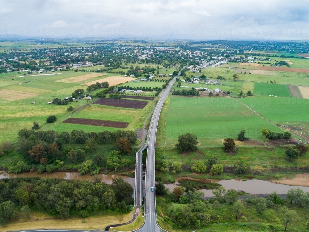 Image of Intersection of country roads going to bridge towards town of ...