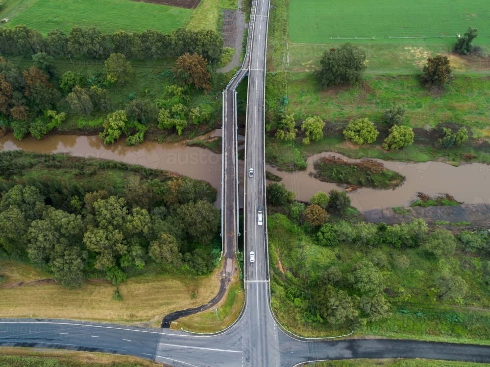 Image of Intersection of country roads going to bridge towards town of ...