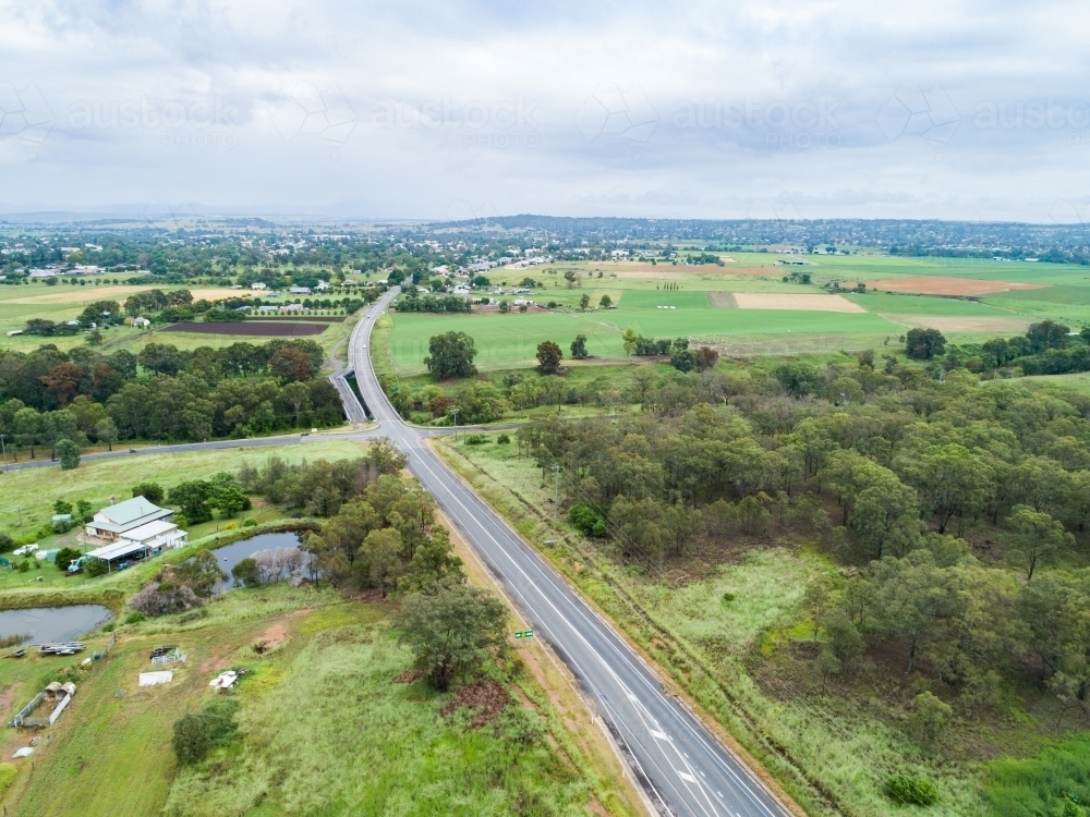 Image of Intersection of country roads going to bridge towards town of ...