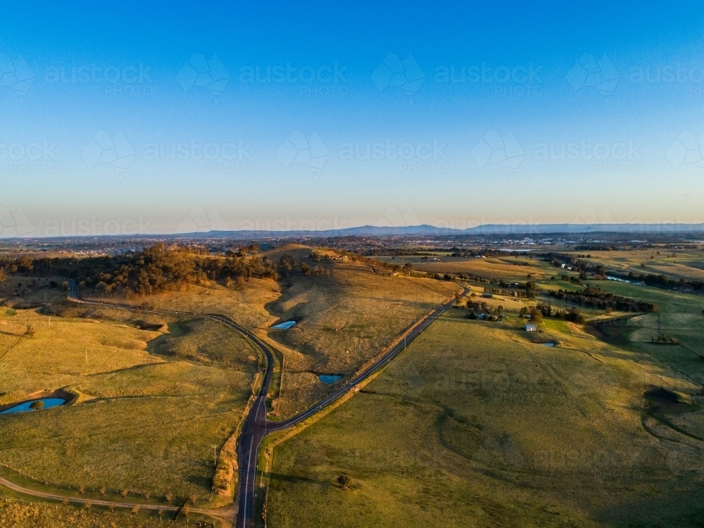 Image of Intersection of country roads in farmland with paddocks bathed ...