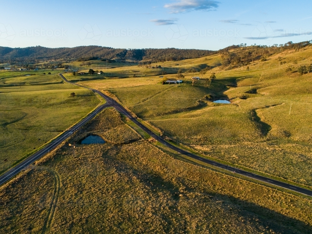 Image of Intersection of country roads in rolling green farmland seen ...