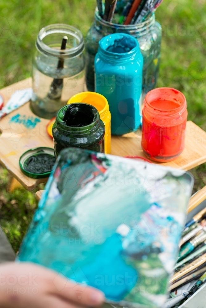 Image of Jars of coloured paint and pallet for mixing - Austockphoto