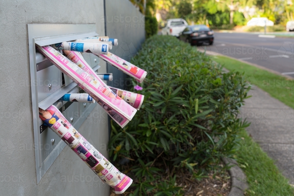 Image of Junk mail sticking out of letter boxes - Austockphoto