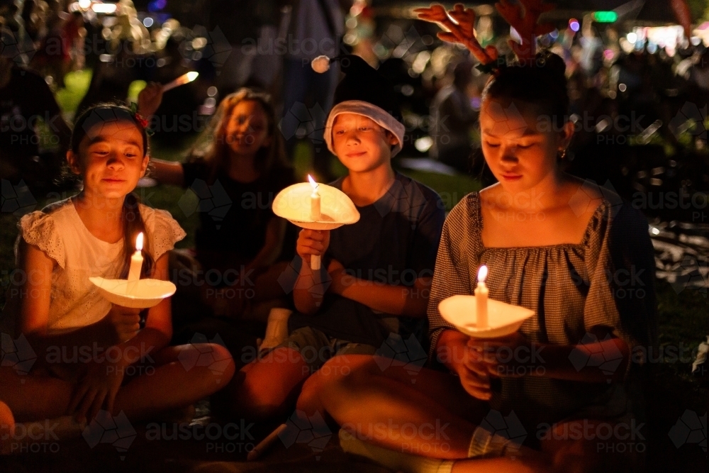 Image of kids holding candles at carols by candlelight - Austockphoto