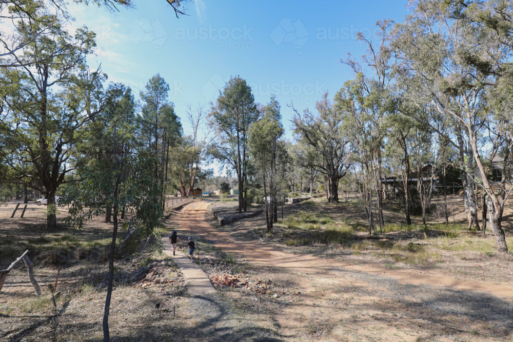 Image of Kids running along footpath in rural Australia - Austockphoto
