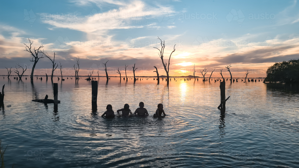 Image of Kids swimming at Kow Swamp in rural Victoria at sunset ...