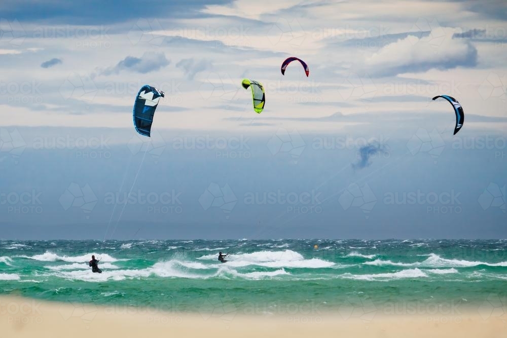 Image of Kite surfers on the water with storm clouds behind. - Austockphoto