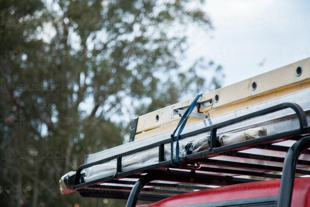 Image of Ladders strapped to the roof racks of a tradie's car ...