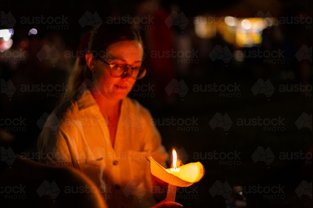 Image of lady holding a glowing candle at carols by candlelight ...