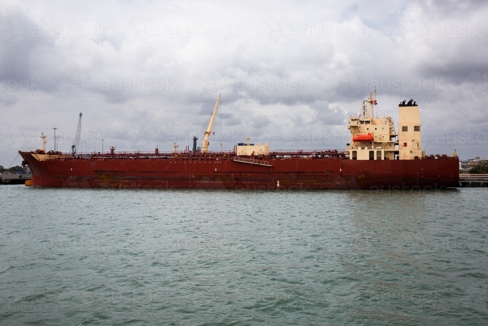 Image of large dark red ship docked in Gladstone harbour - Austockphoto