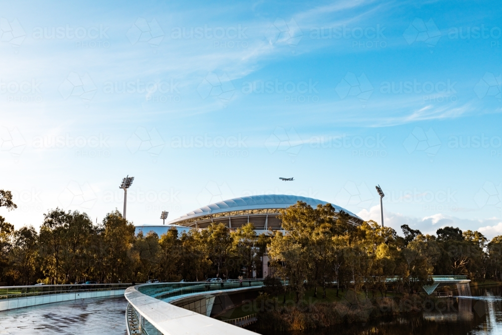 Image of Large passenger plane flying over Adelaide Oval - Austockphoto