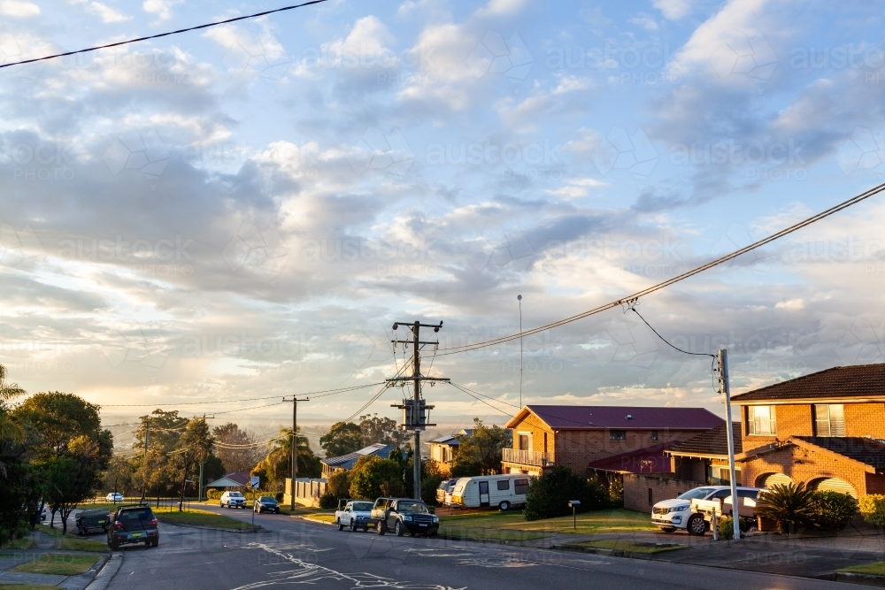 Image of last light of the day on houses lining street in city outer ...