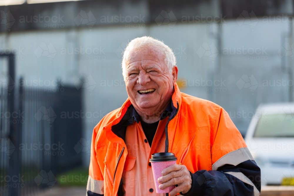 Image of Laughing older Aussie workman in high vis on cold morning with ...